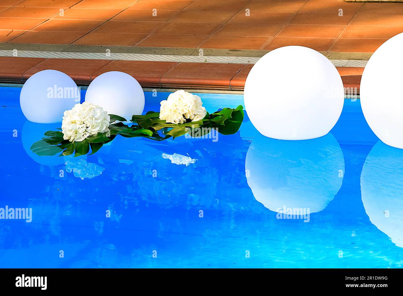 Swimming pool border decorated with white floating balls and fresh ...