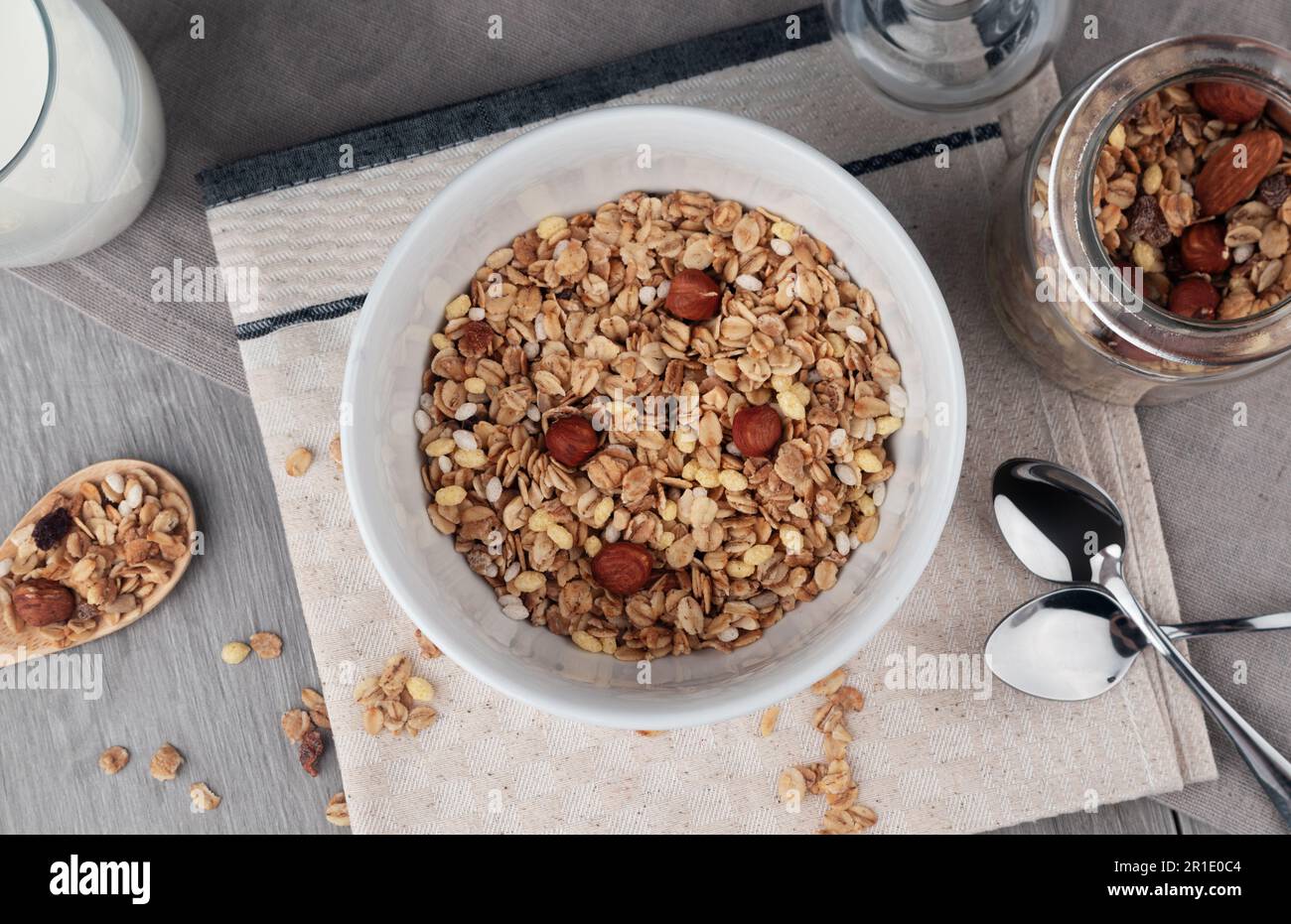 Crispy granola with nuts in bowl on light table background. Healthy ...