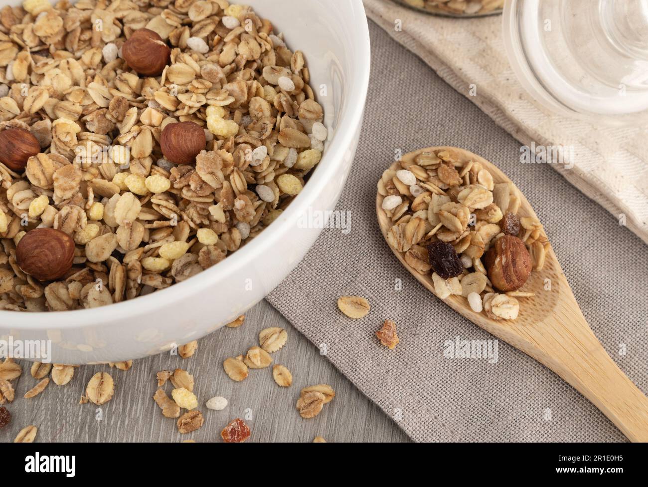 Crispy granola with nuts in bowl on light table background. Healthy ...