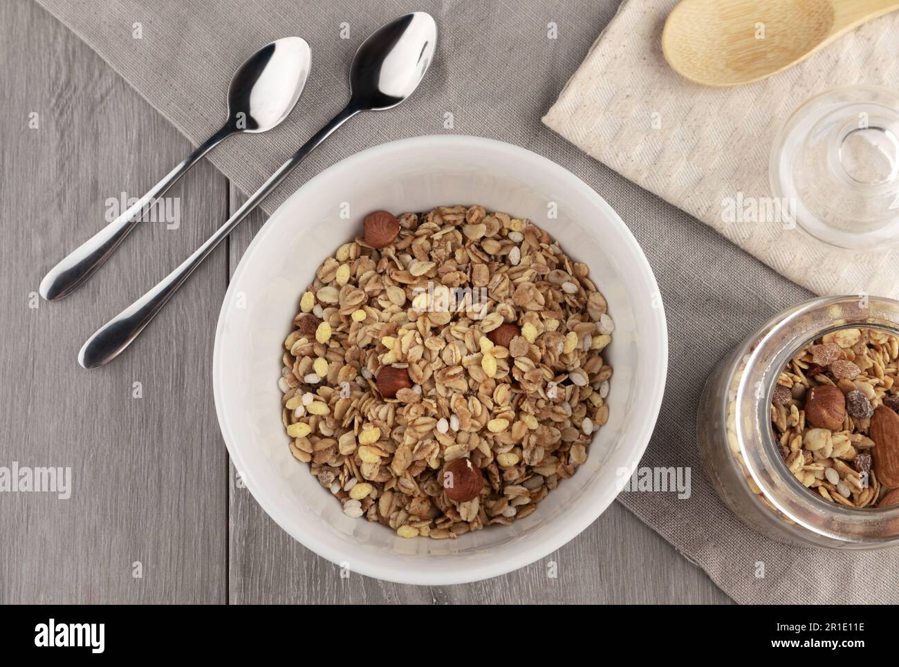 Crispy granola with nuts in bowl on light table background. Healthy ...