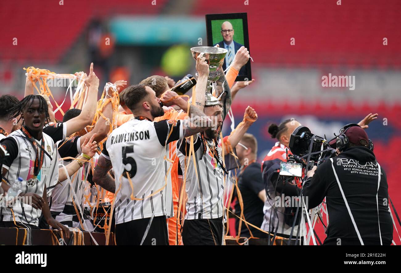 Notts County players hold up the trophy and a picture of CEO Jason ...