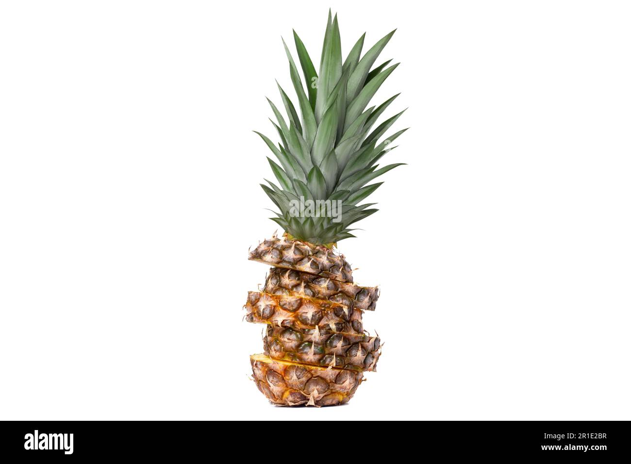 A close-up image of a yellow and green pineapple cut into slices with a ...