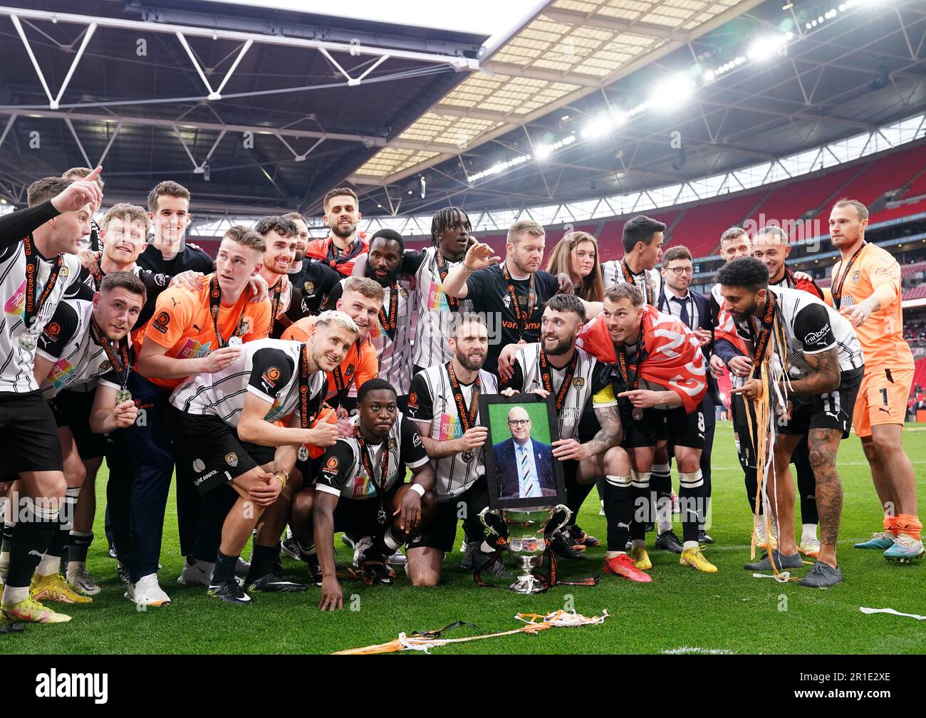 Notts County players pose with the trophy and a picture of CEO Jason ...
