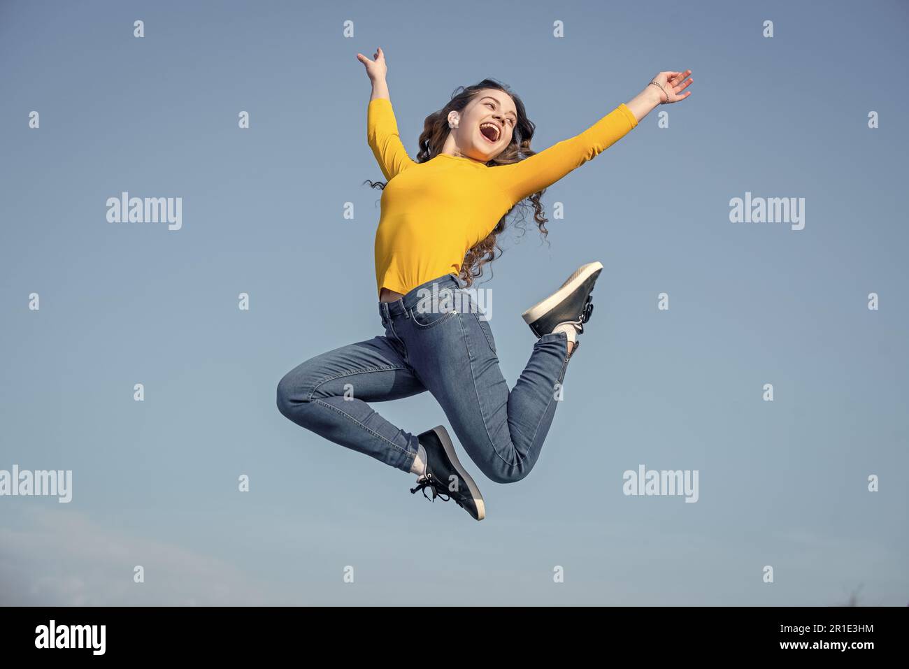 happy teen girl jumping on sky background Stock Photo - Alamy