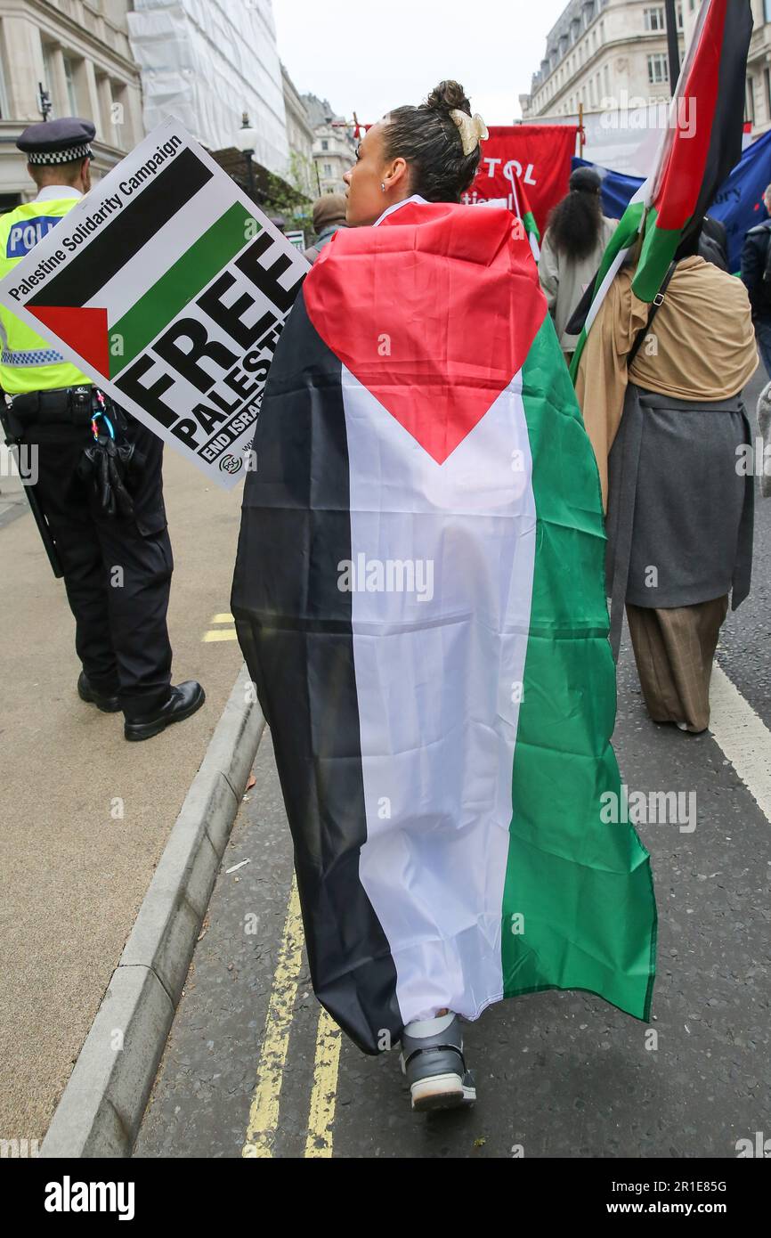 London, UK. 13th May, 2023. A woman wrapped in a flag of Palestine ...