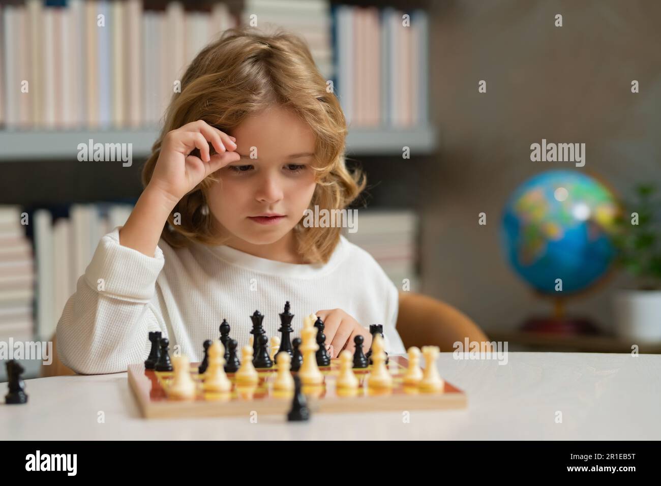 Kid thinking of chess. Little child play chess. Kid playing board game ...