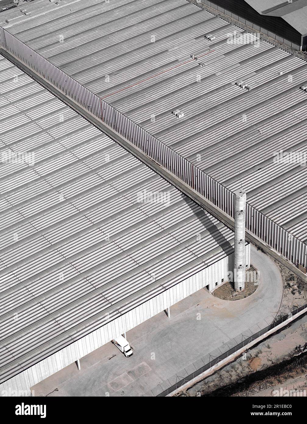 Aerial photograph of a giant Warehouse roof and a tower with single ...
