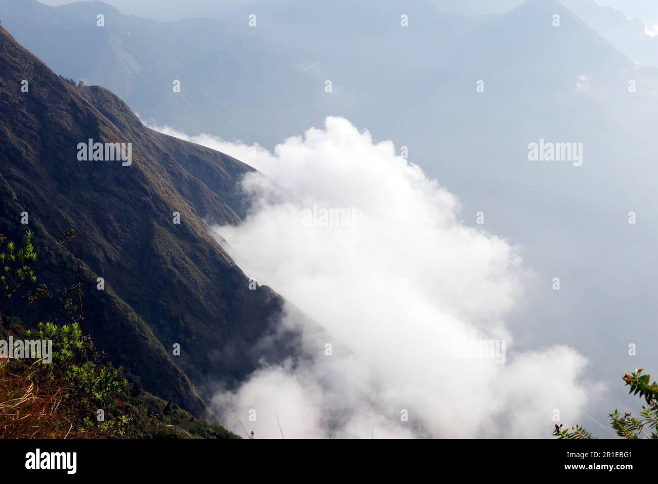 beautiful tall rock mountain top view with clouds under in munnar ...