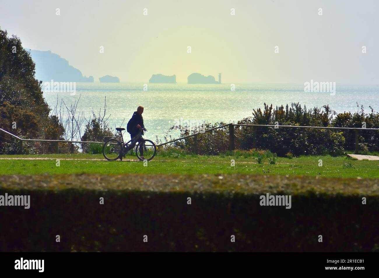 Man walking with bicycle along the coastal path with Isle of Wight ...