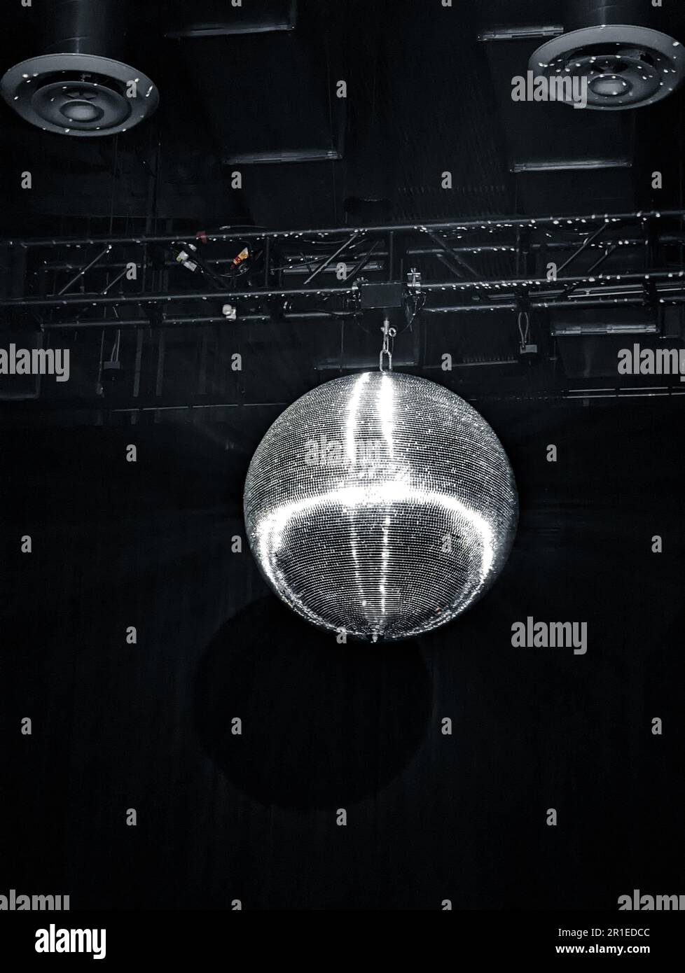 An illuminated disco ball hangs from the ceiling in a spacious ...
