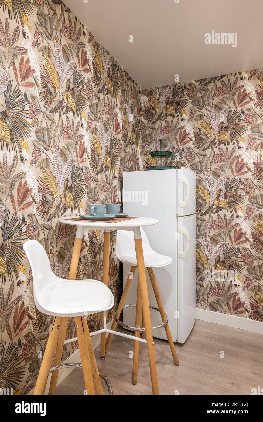 Compact high small round table with cups and two bar stools in the ...