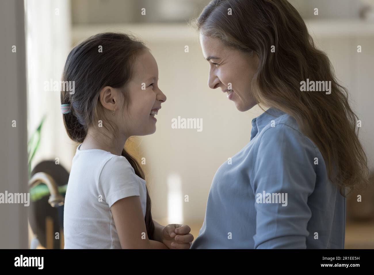 Positive mom holding cute little girl, talking to sweet kid Stock Photo ...