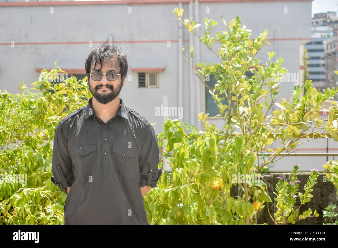 A handsome young man in black kabli panjabi standing in garden Stock ...