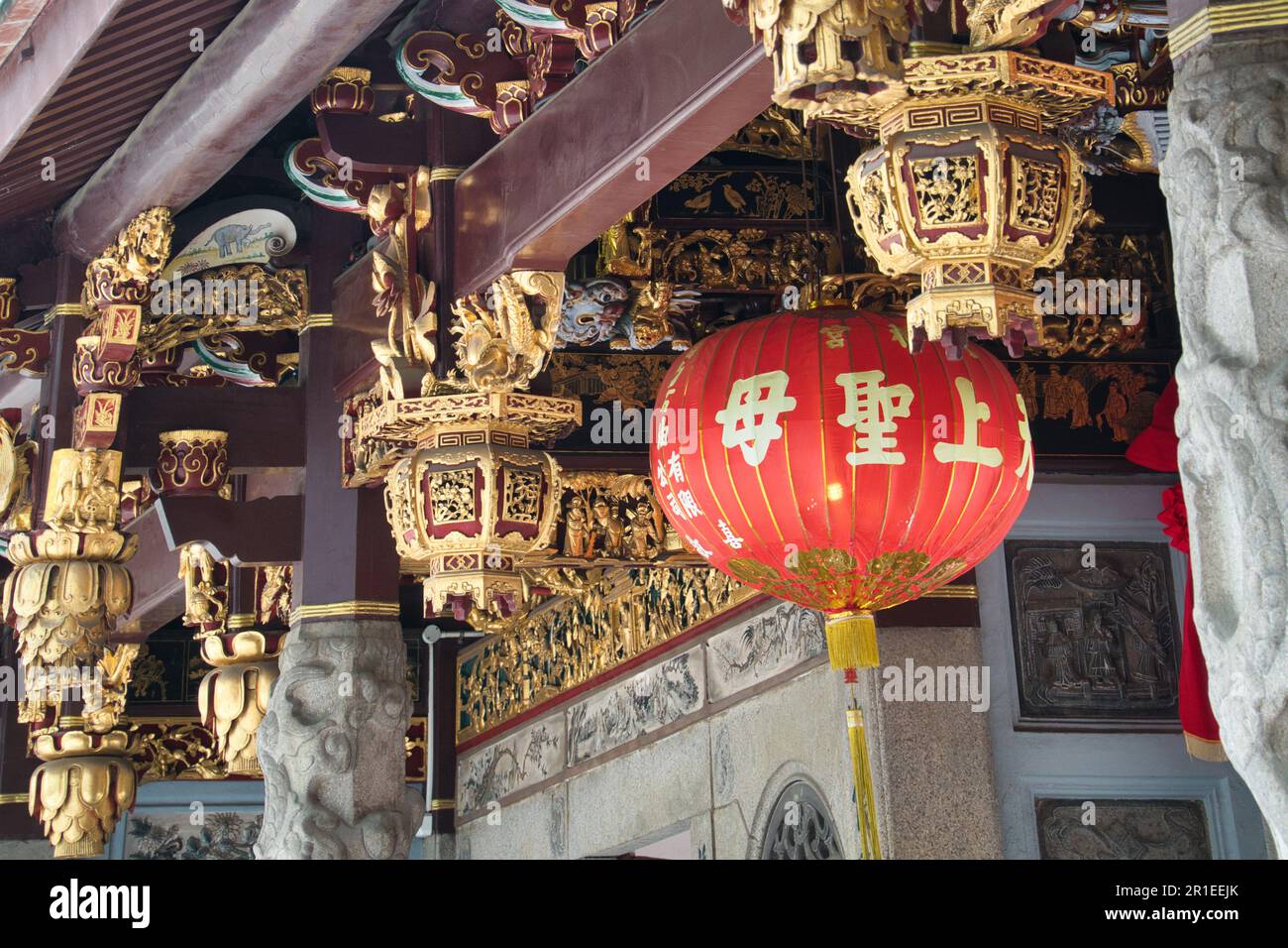 A large ornamental lantern hanging from the ceiling of a temple in ...