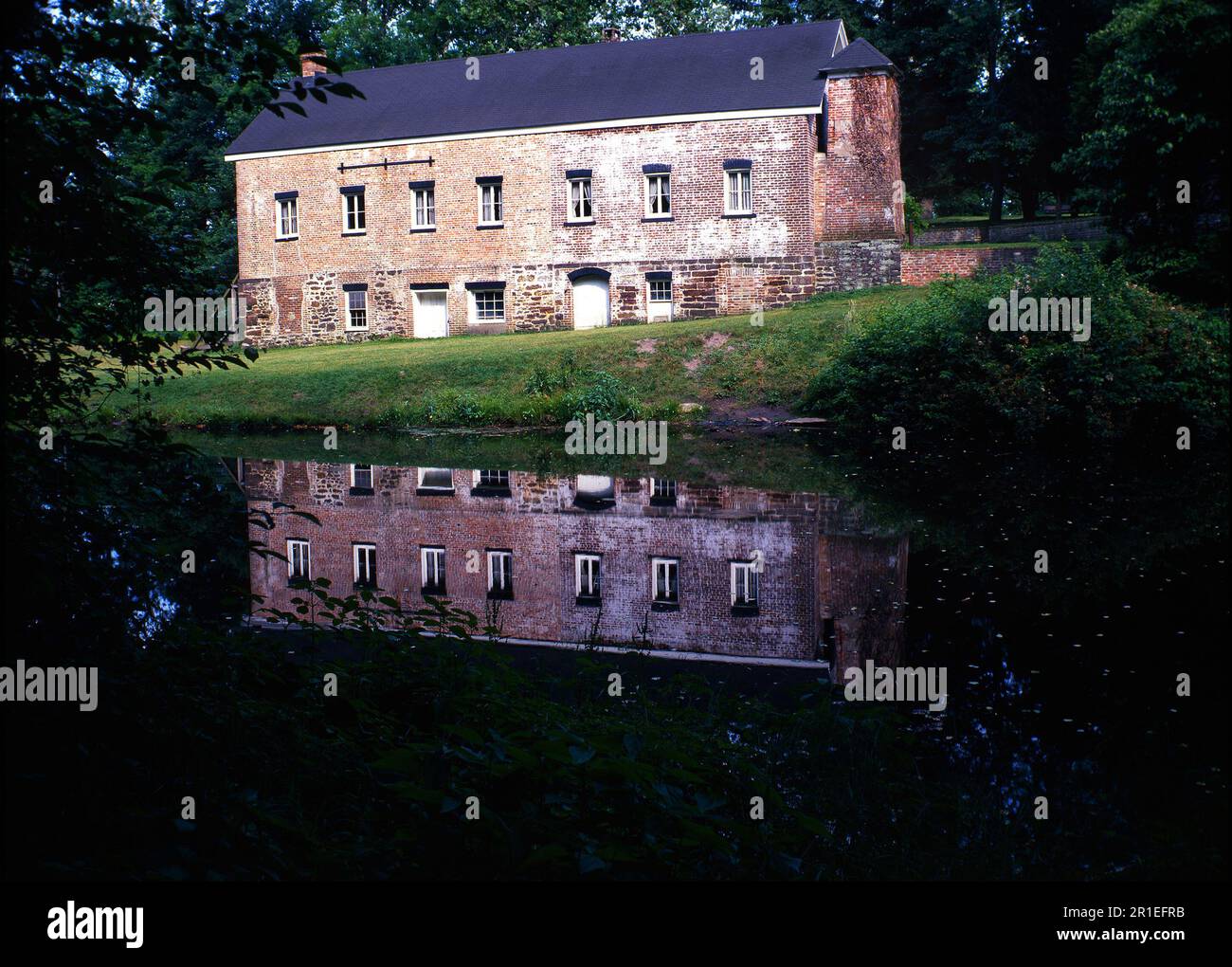 Old iron mill building on a lake Stock Photo - Alamy
