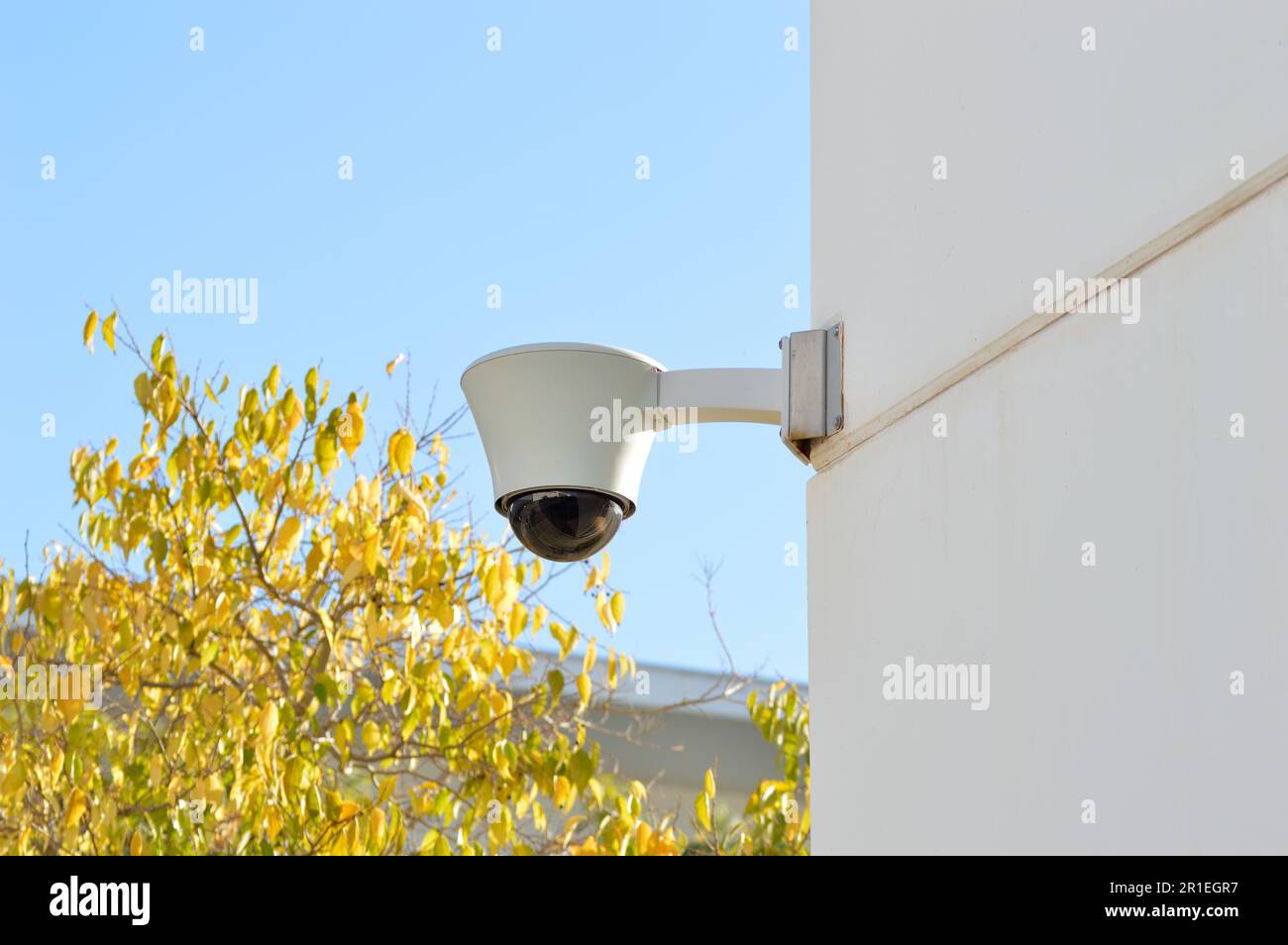 security camera working on the wall of a building Stock Photo - Alamy