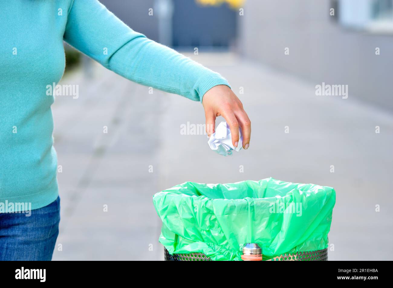 Civic woman throwing garbage in a trash bin a city Stock Photo - Alamy
