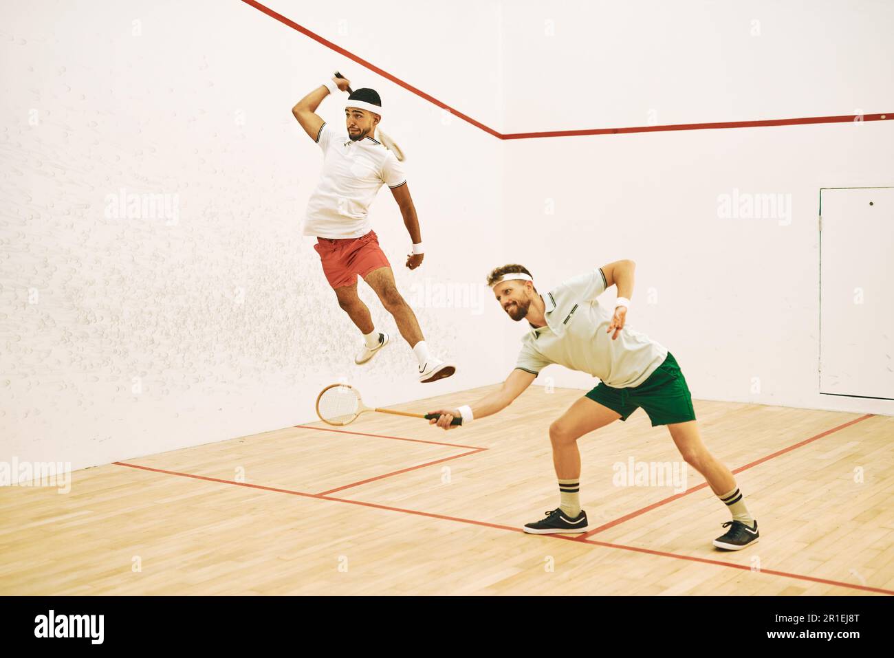 Stay light on your feet. two young men playing a game of squash Stock ...