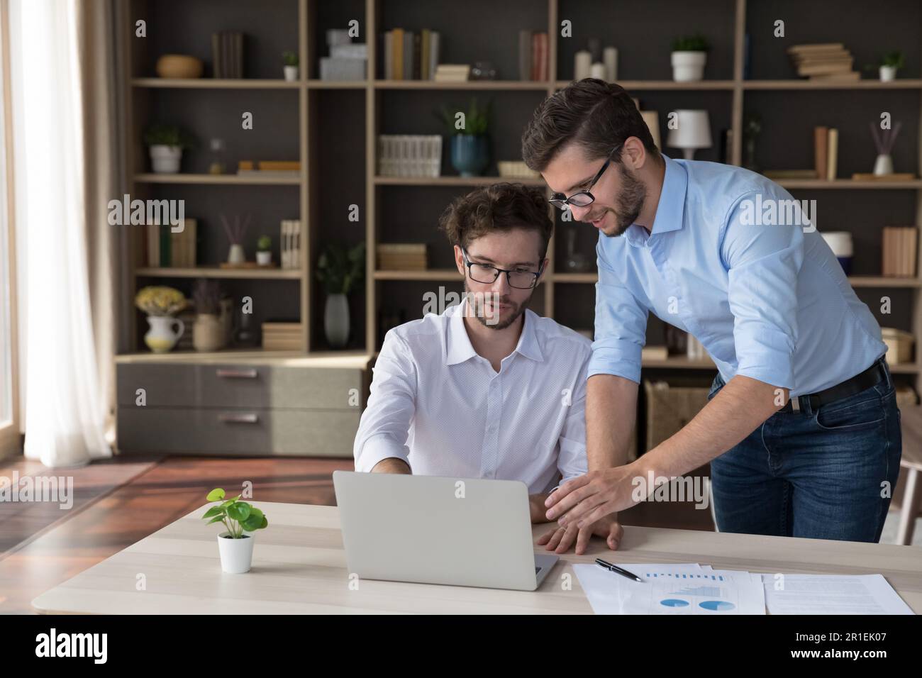 Busy engaged young twin brothers working on family business company ...