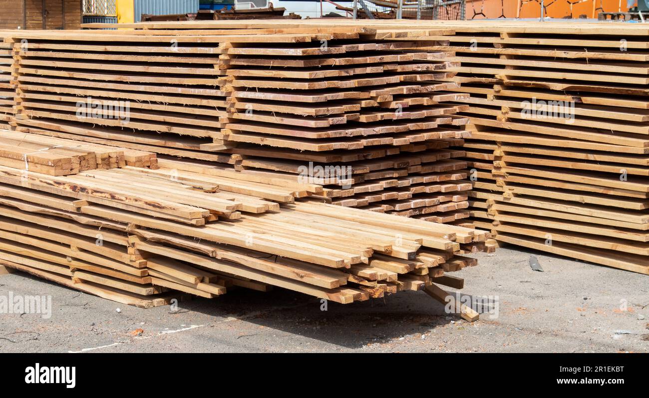 Pile of stacked wooden planks at a construction site. Wooden boards ...