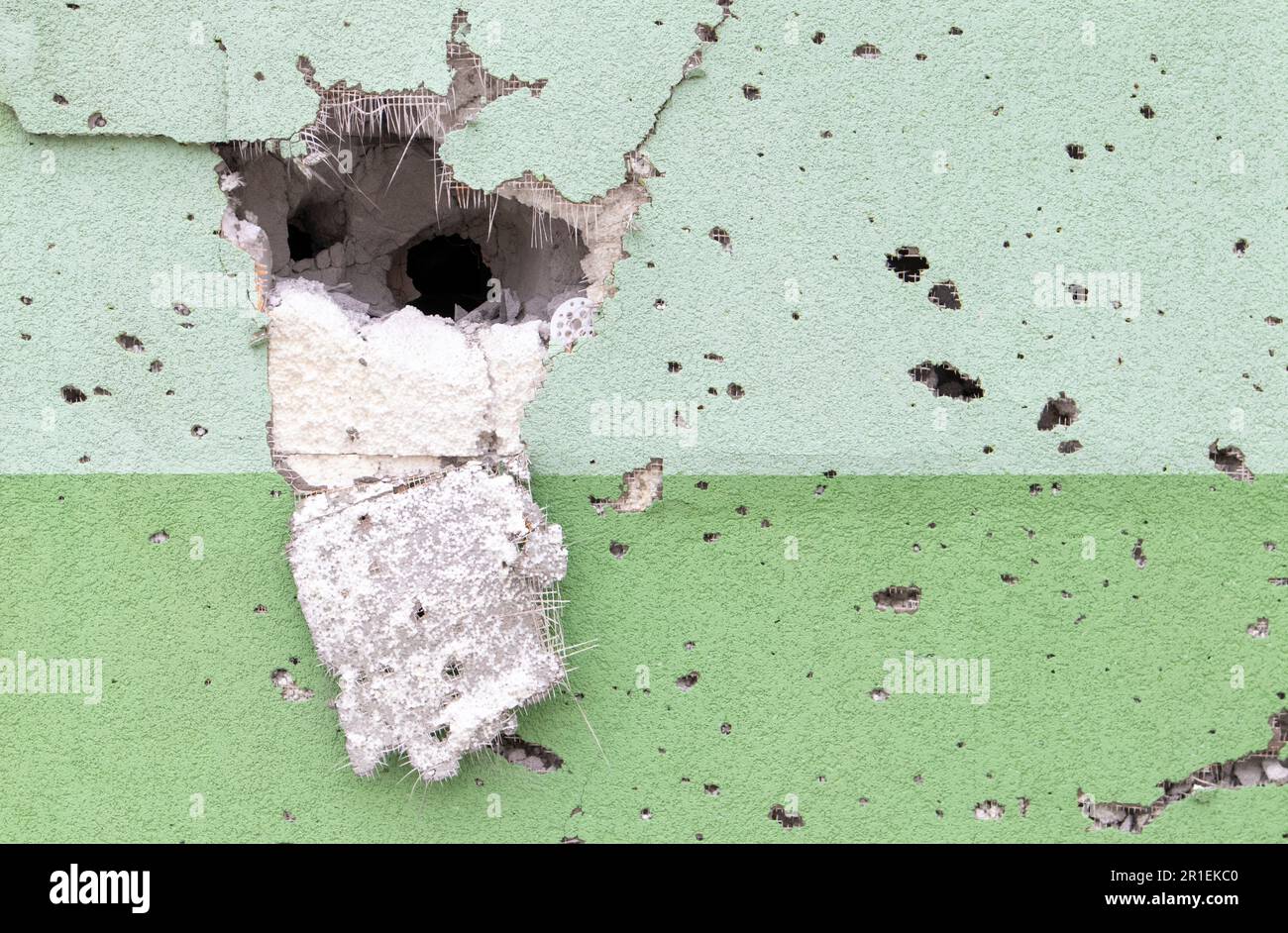 Holes from bullets and shrapnel in the wall on the front line. Scars of ...