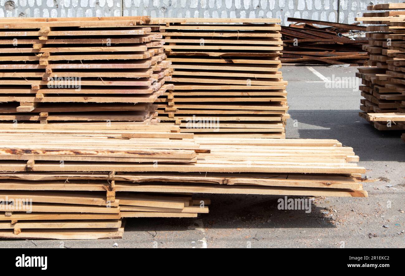 Pile of stacked wooden planks at a construction site. Wooden boards ...