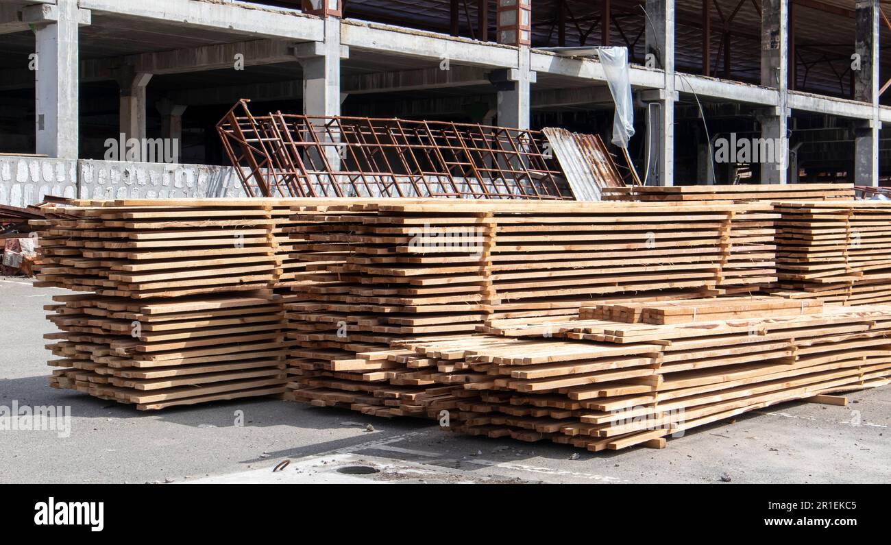 Pile of stacked wooden planks at a construction site. Wooden boards ...