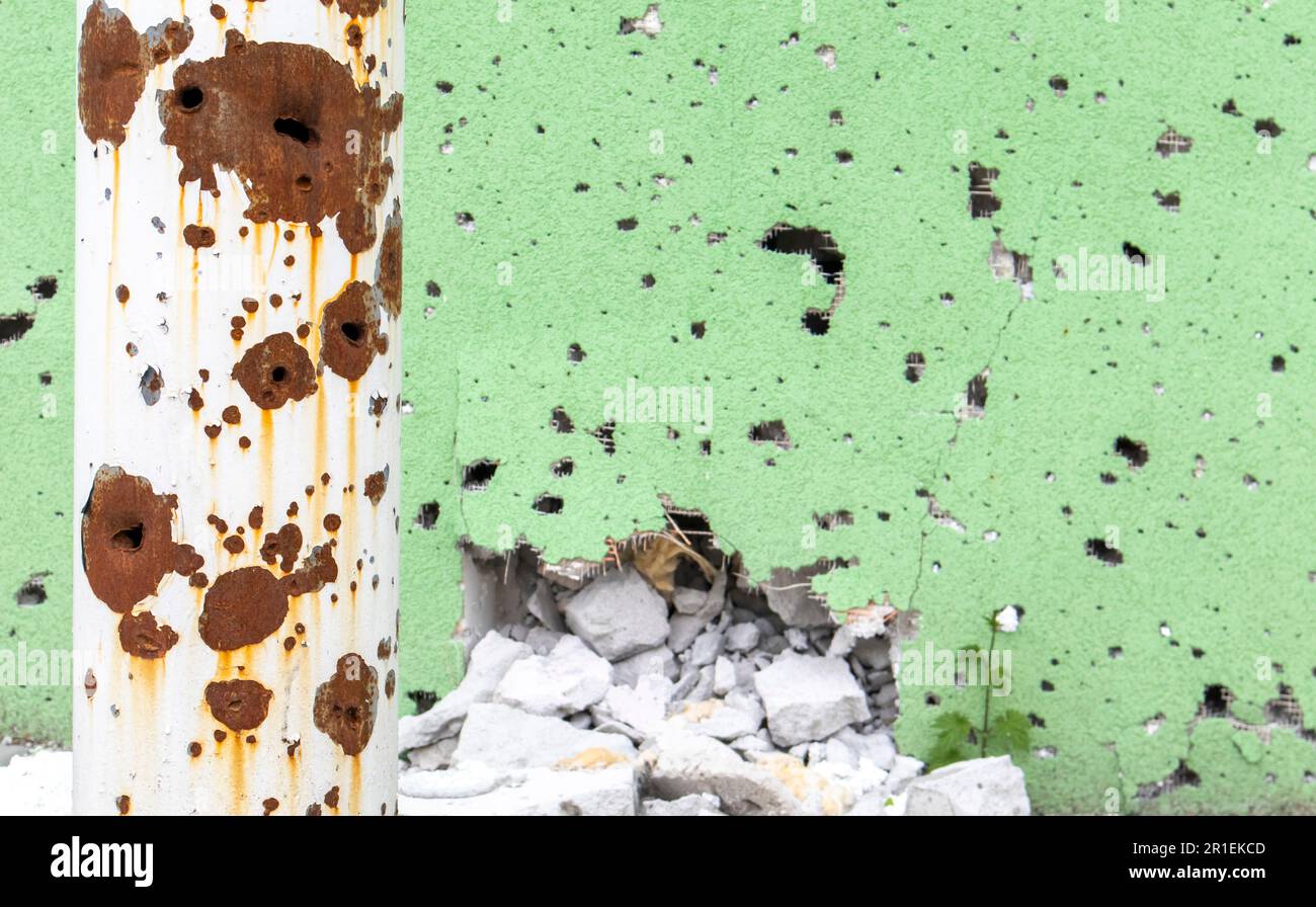 Holes from bullets and shrapnel in the wall on the front line. Scars of ...