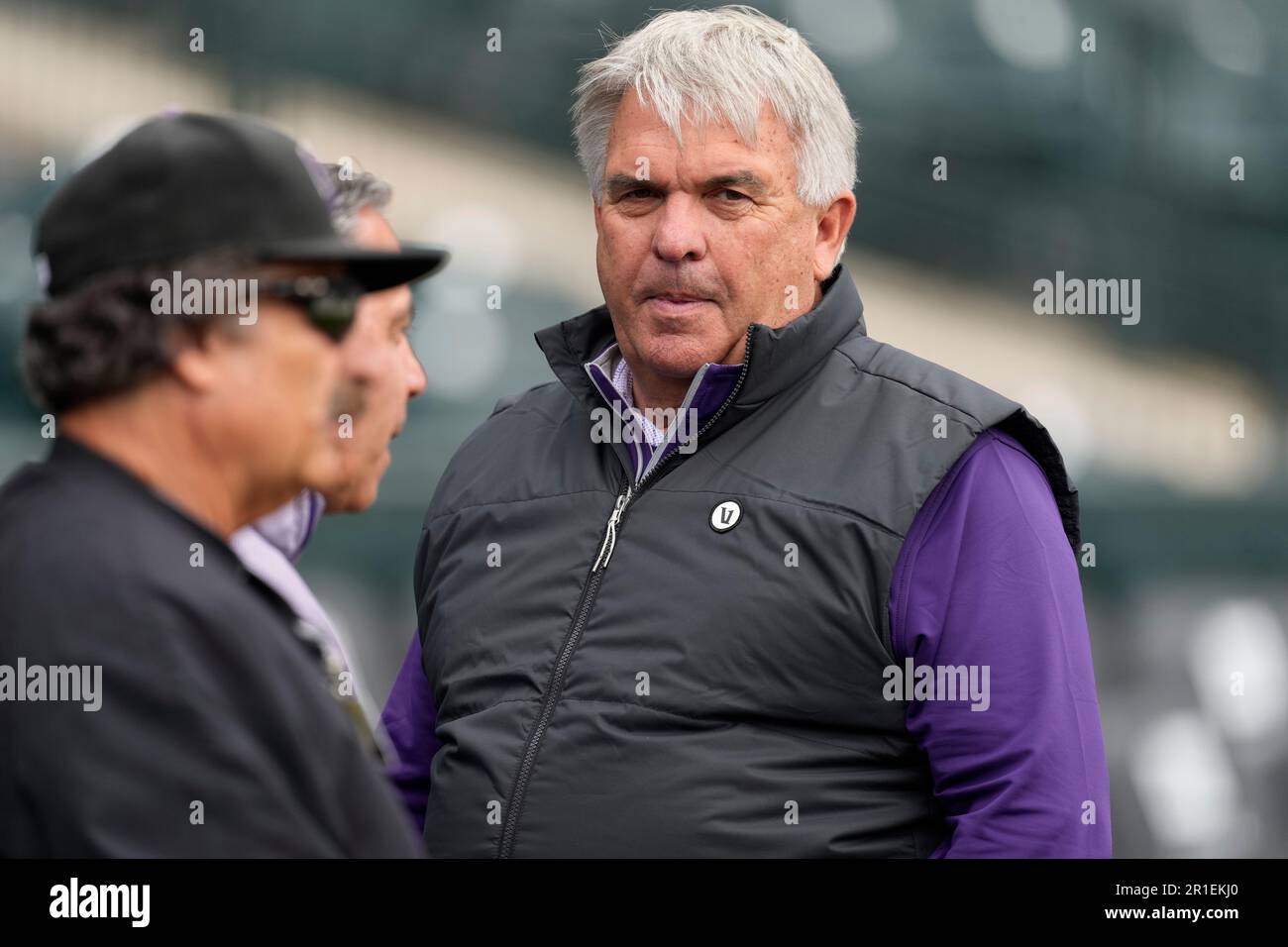 Colorado Rockies general manager Bill Schmidt looks on as players warm up before a baseball game ...