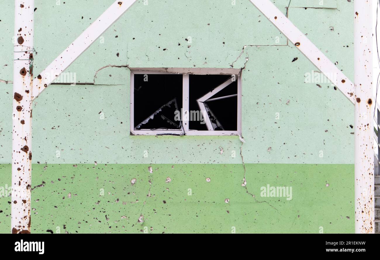 The wall of a building battered by rocket fragments in a war zone ...