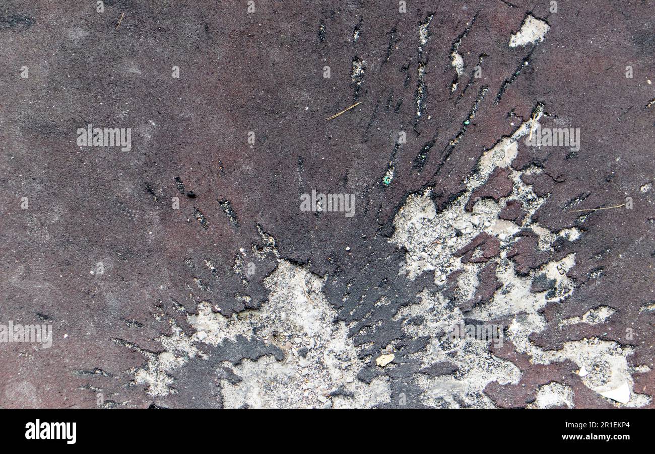 War in Ukraine. Funnel from the explosion in the asphalt. The trace ...