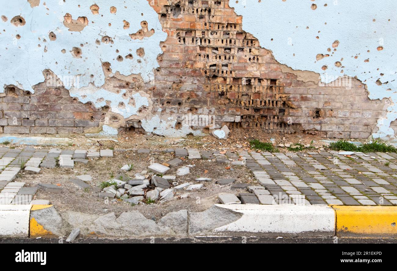 War in Ukraine. Funnel from the explosion in the asphalt. The trace ...