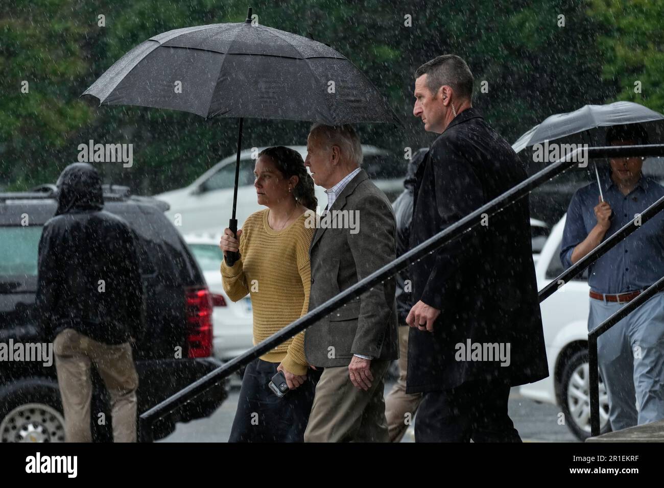 President Joe Biden walks with Annie Tomasini in the rain from St ...