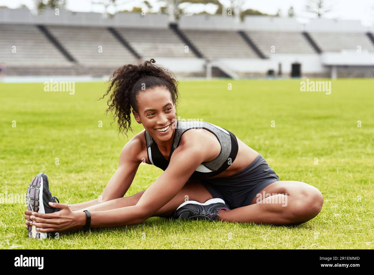 Stretching is the first step. Full length shot of an attractive young female athlete warming up ...