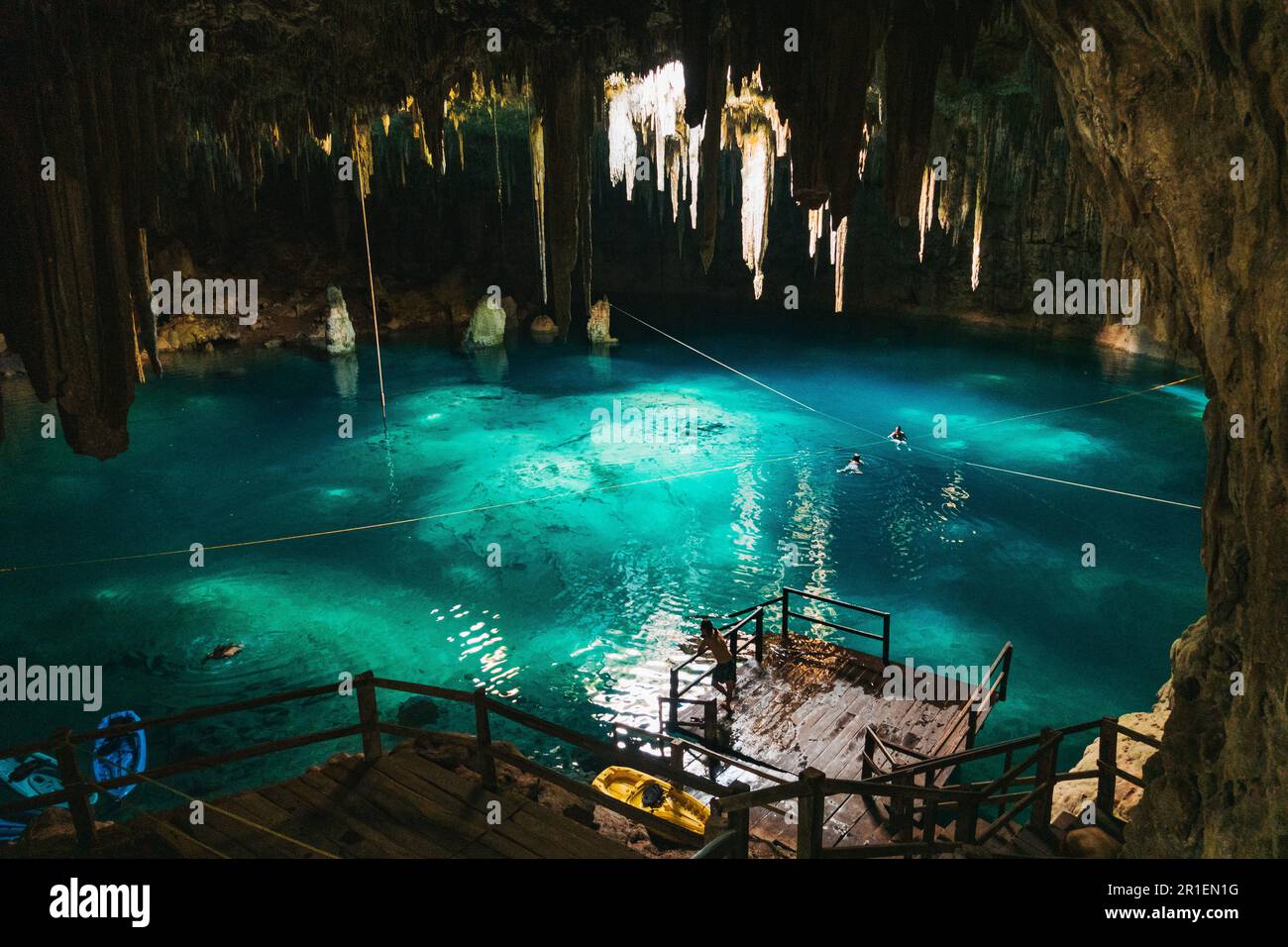 a swimmable cenote – a natural underground pool caused by a sinkhole in the bedrock filling with ...