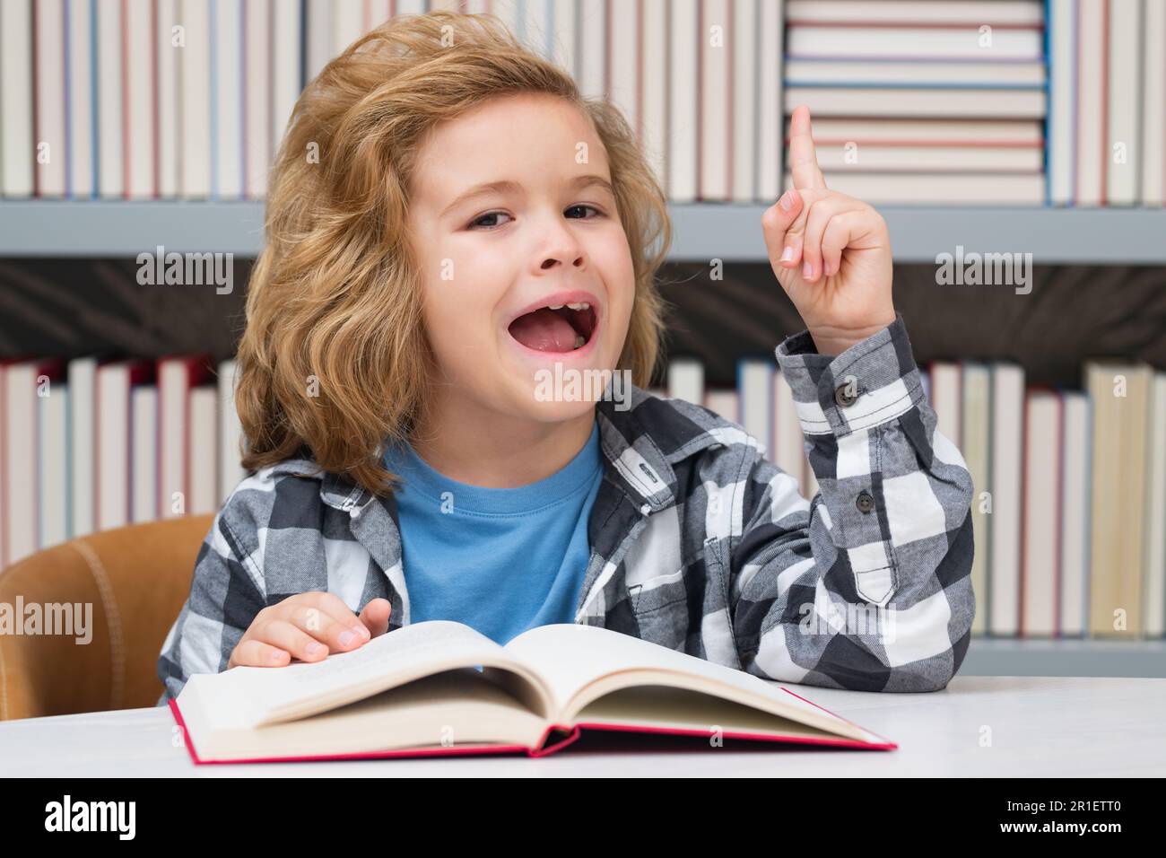 Kid reading book in a book store or library Stock Photo - Alamy