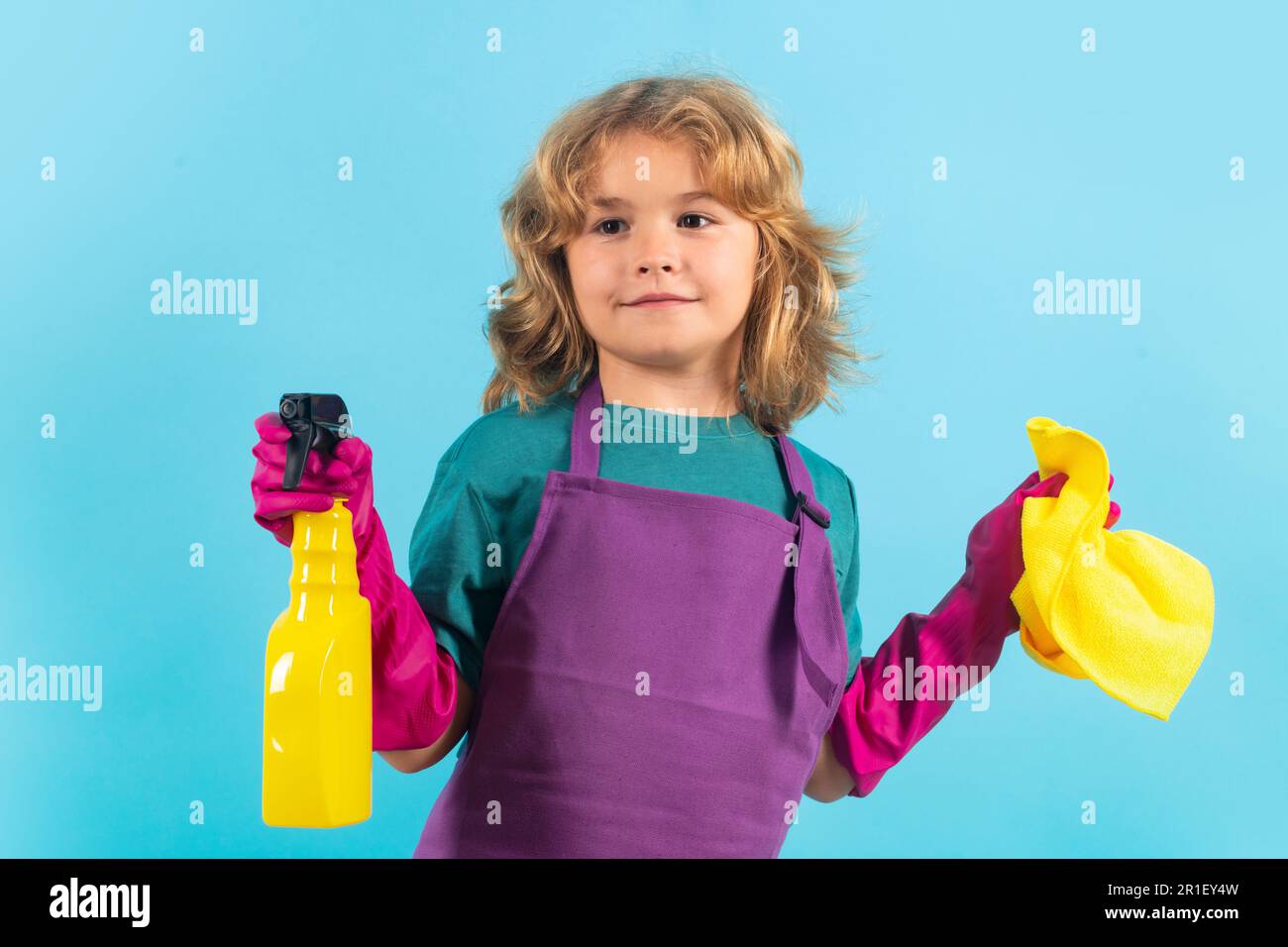 Studio portrait of child helping with housework, cleaning the house ...