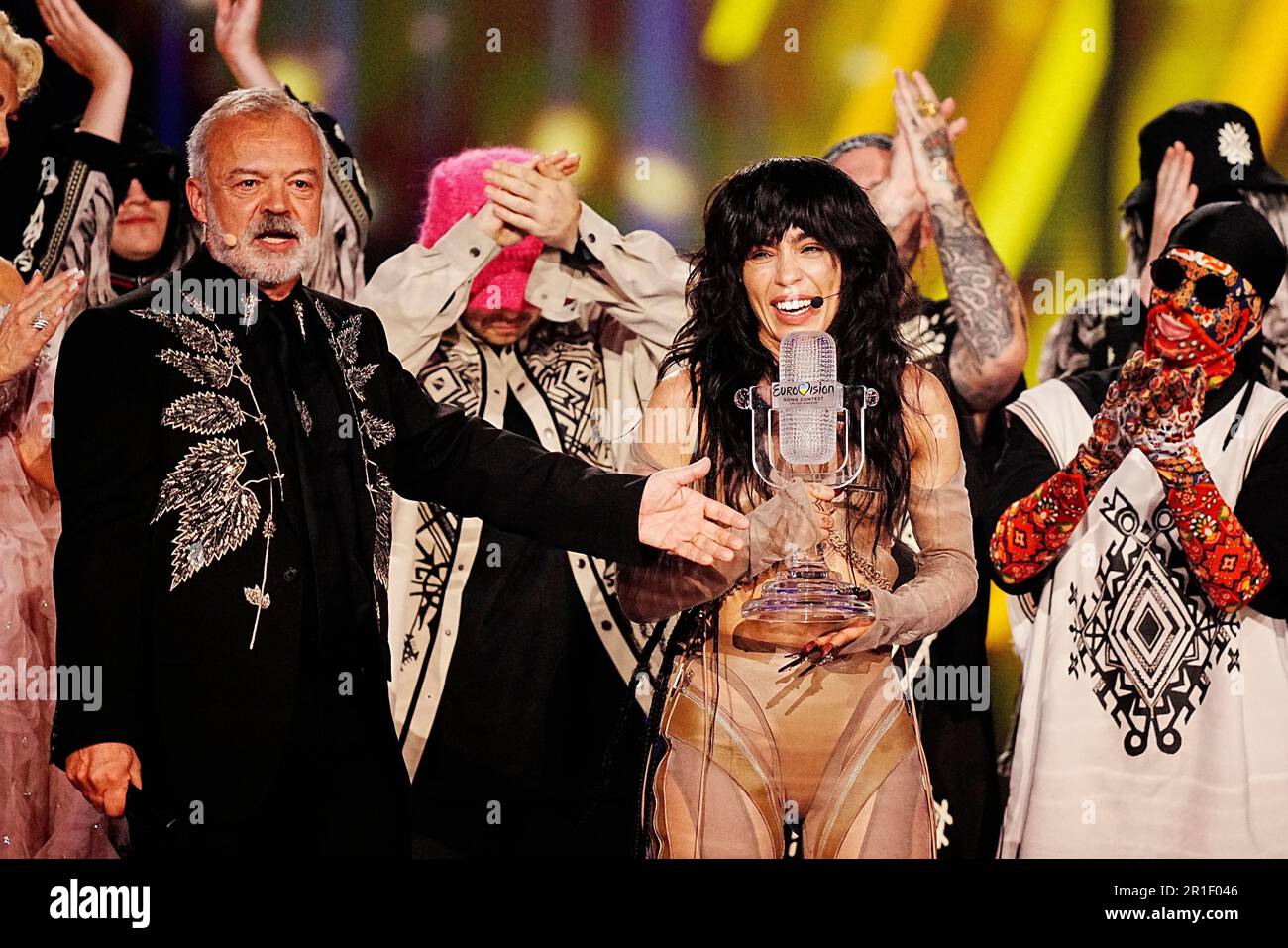 Sweden entrant Loreen is presented with the trophy by Kalush Orchestra ...