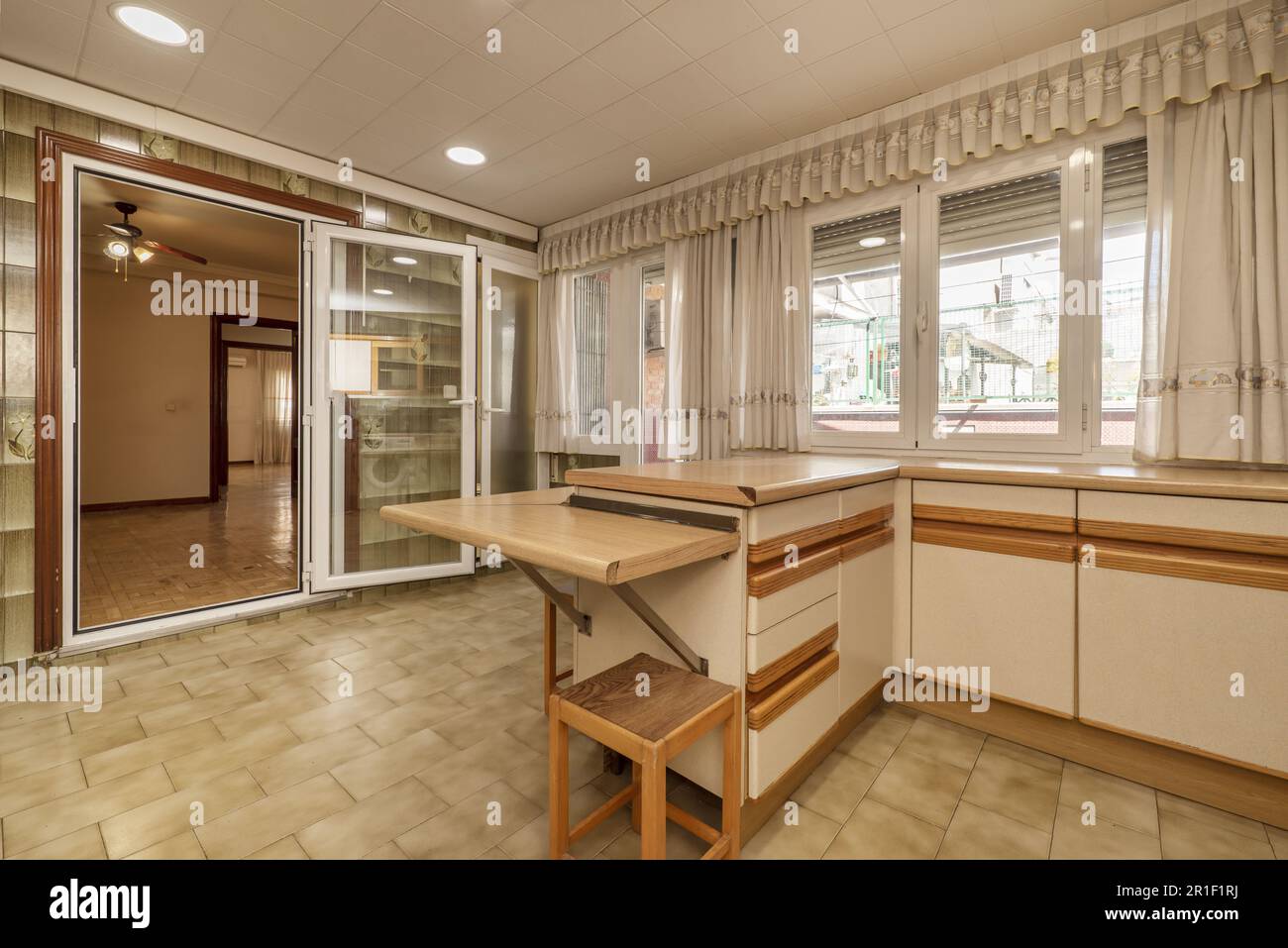 A kitchen filled with light colored column cabinets with wood bevels ...