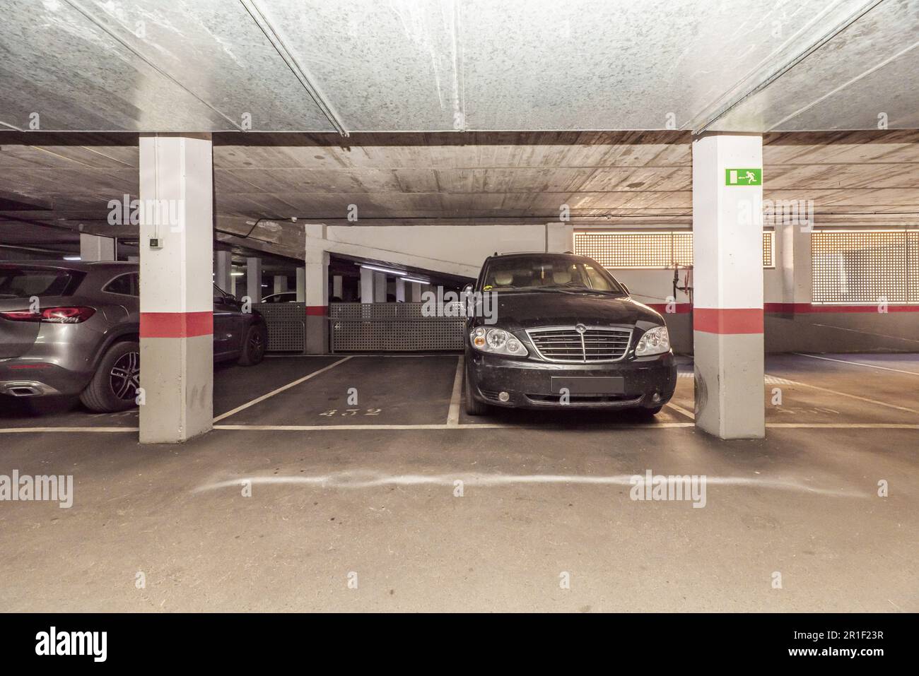 A garage with empty spaces and some parked cars Stock Photo - Alamy