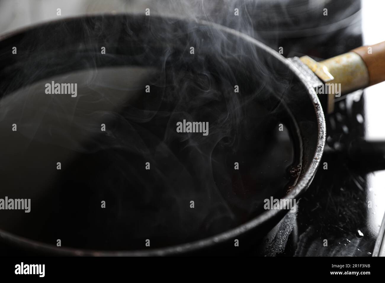 Frying pan with hot used cooking oil on stove, closeup Stock Photo - Alamy