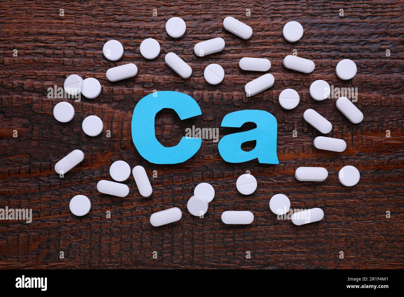 Paper symbol Ca (Calcium) and pills on wooden table, top view Stock ...