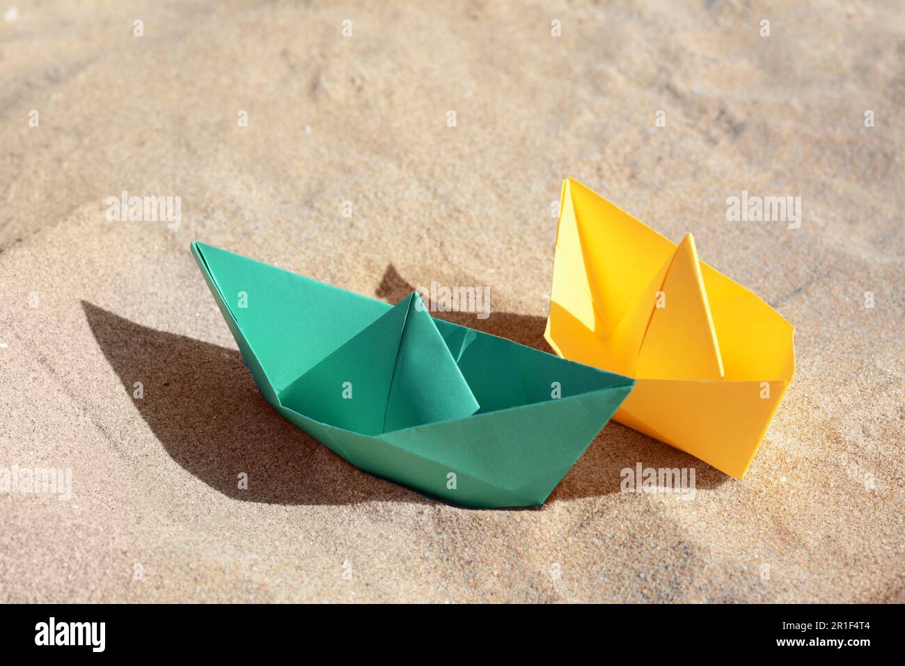 Two color paper boats on sandy beach Stock Photo - Alamy