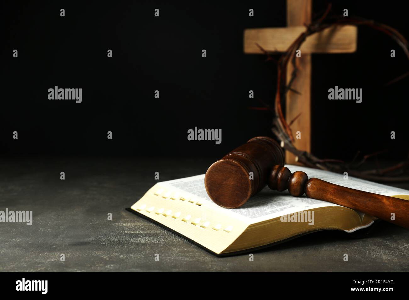 Judge gavel, bible, wooden cross and crown of thorns on grey table ...