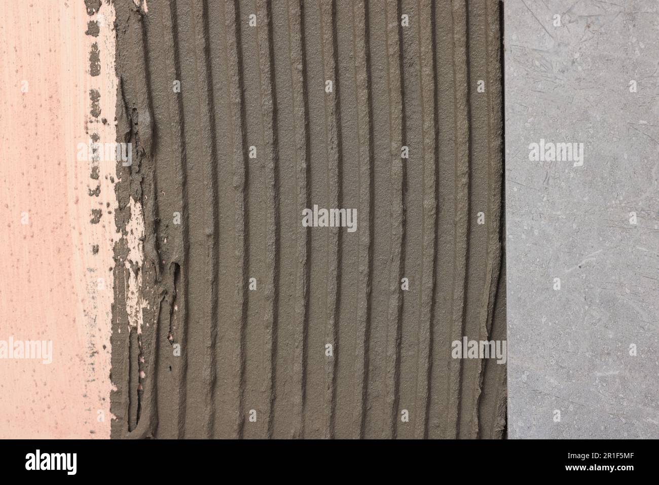 Tile and adhesive mix on wall, closeup Stock Photo - Alamy