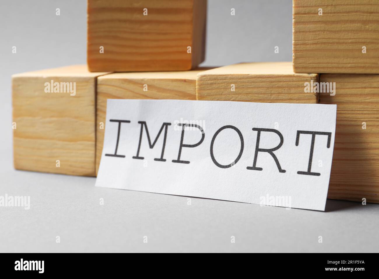 Card with word Import and wooden cubes on light grey background ...