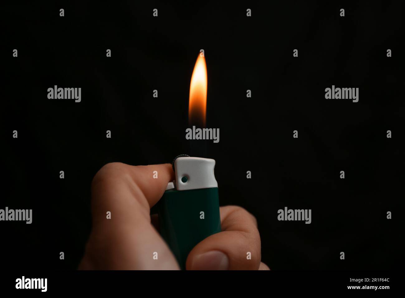 Woman holding lighter on black background, closeup Stock Photo - Alamy