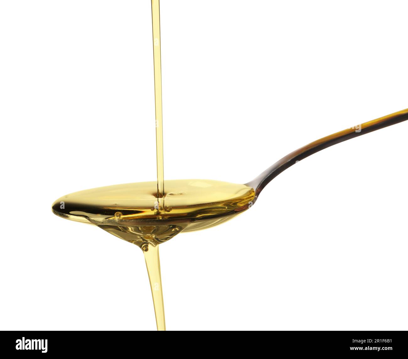 Pouring cooking oil into spoon on white background Stock Photo - Alamy