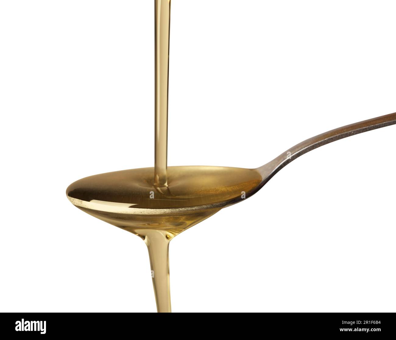 Pouring cooking oil into spoon on white background Stock Photo - Alamy