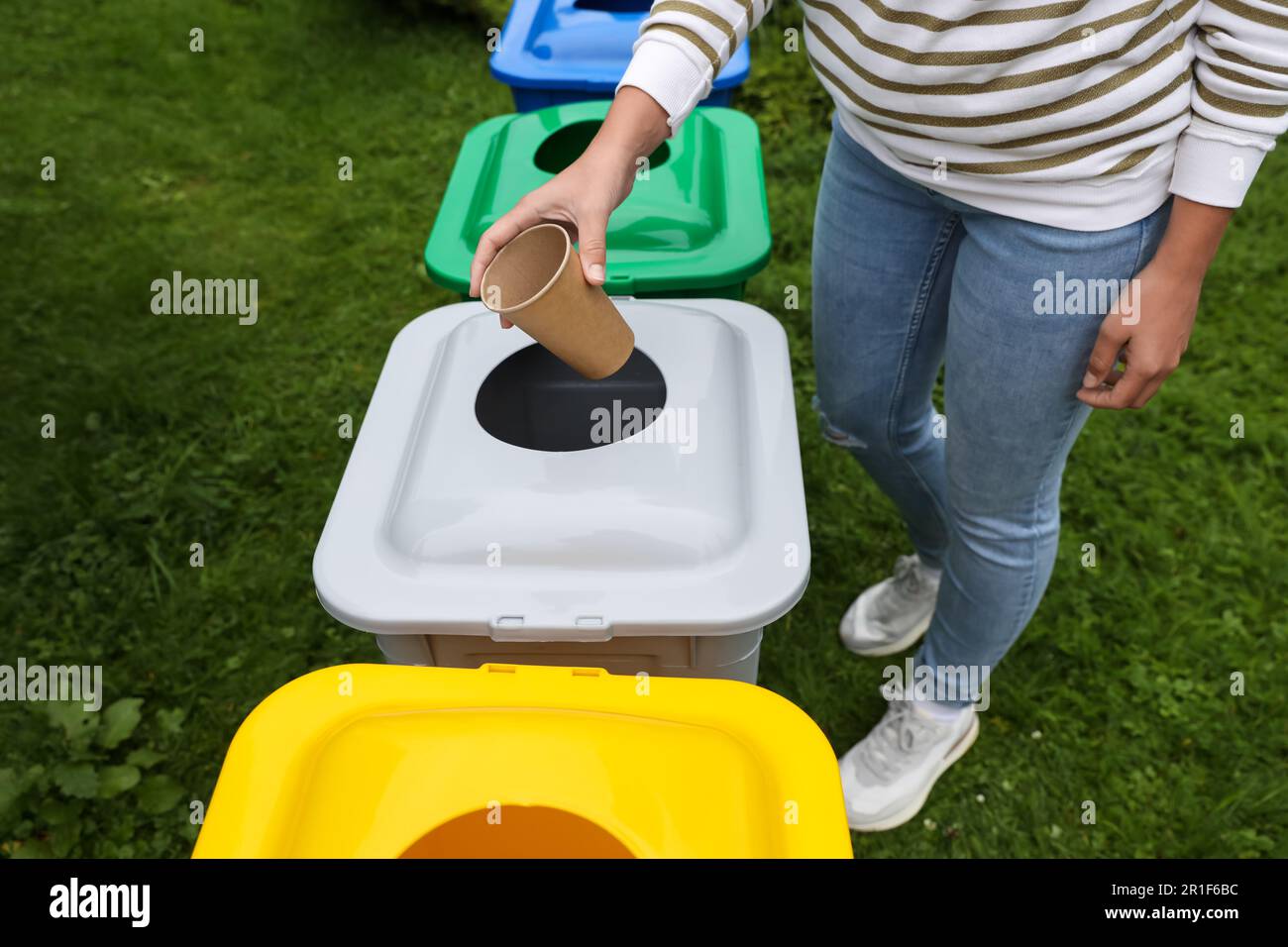 Woman throwing coffee cup into recycling bin outdoors, closeup Stock ...